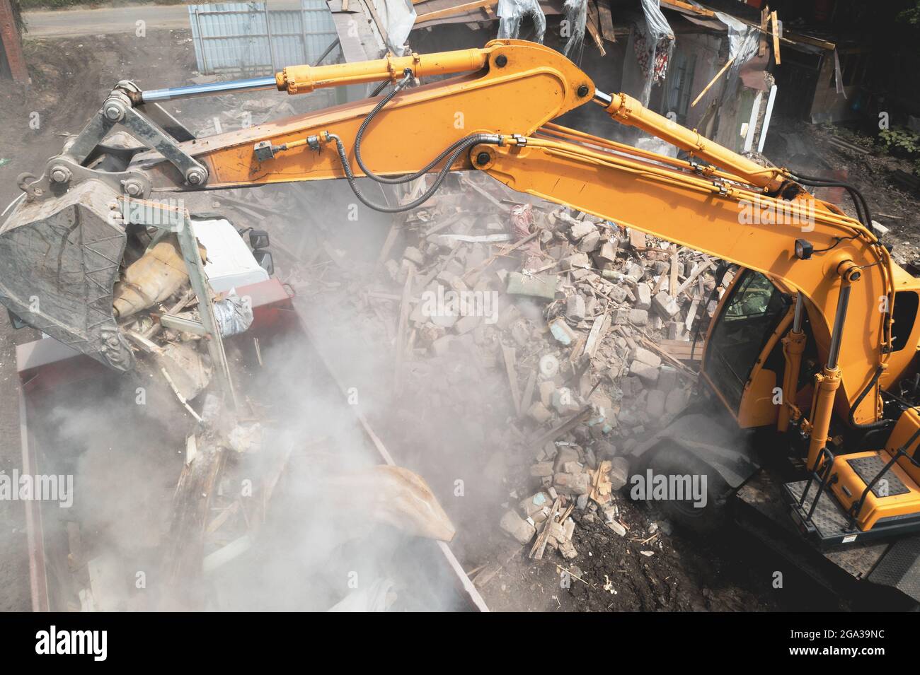 Demolition of building by industrial excavator. Bucket breaks walls and ...
