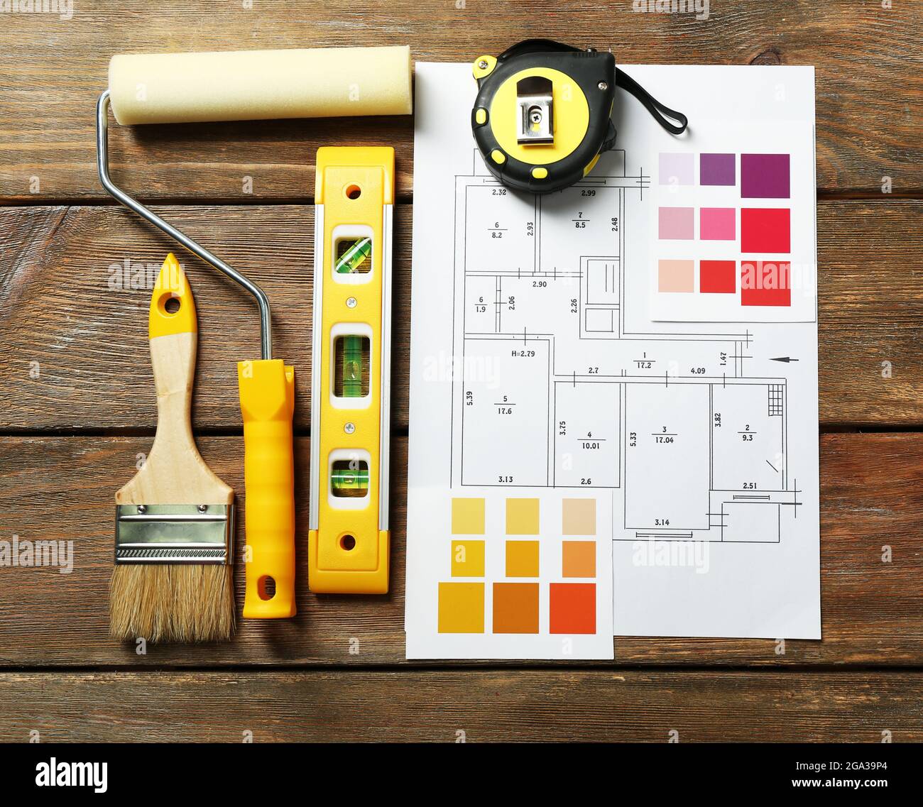 Construction instruments, plan and brushes on wooden table background ...