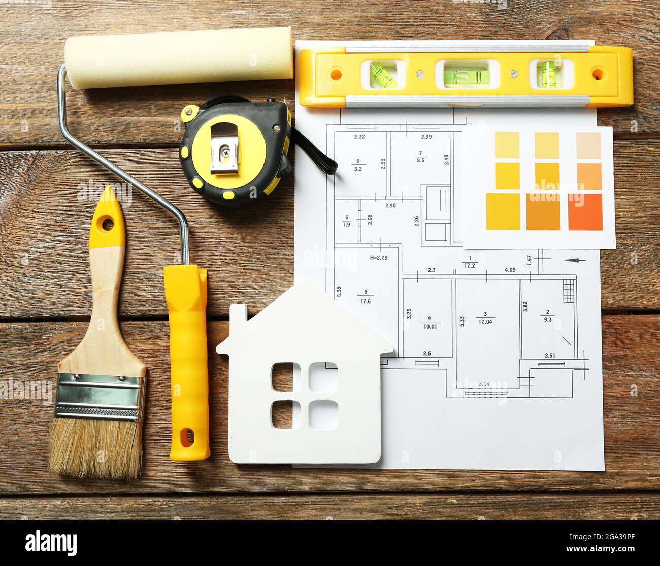 Construction instruments, plan and brushes on wooden table background ...