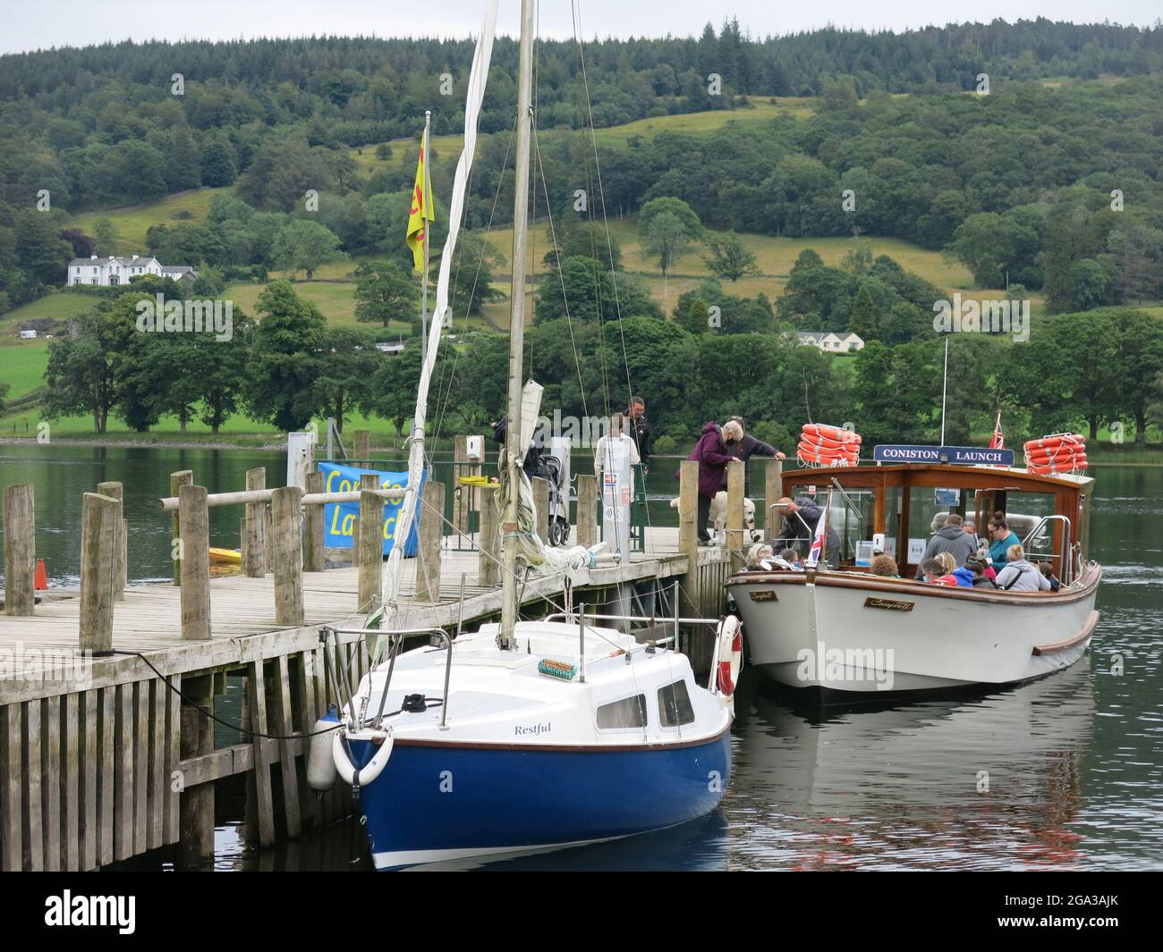 Boats moored at the jetty and on the lakeshore, Coniston Pier at ...