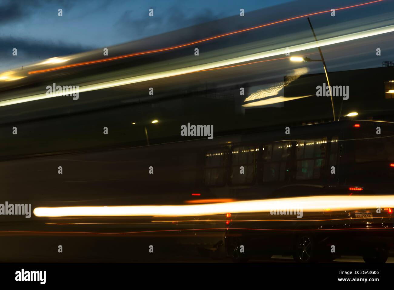 Night city traffic with cars and buses passing by. Photo effect at low ...