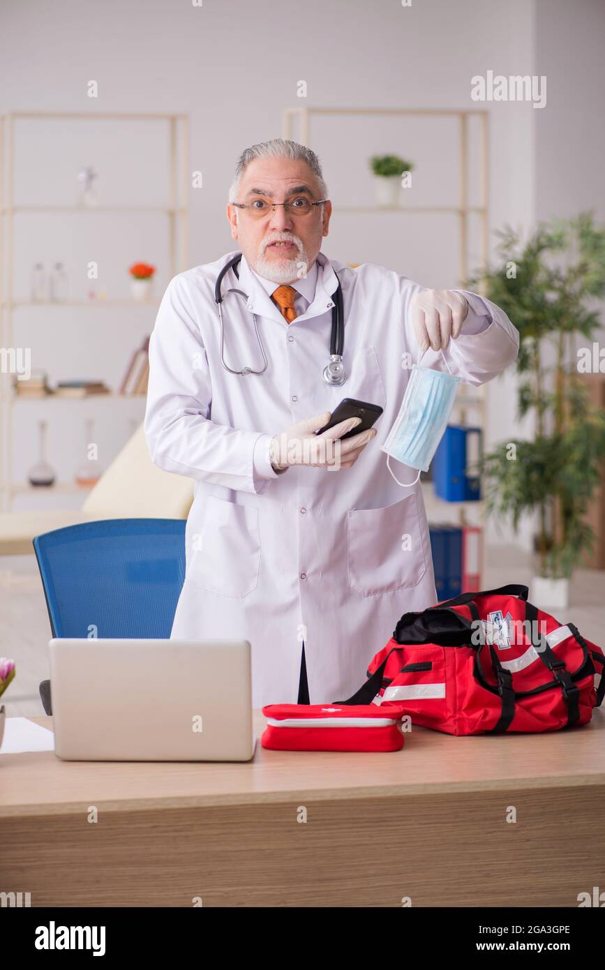 Old doctor in first aid concept Stock Photo - Alamy