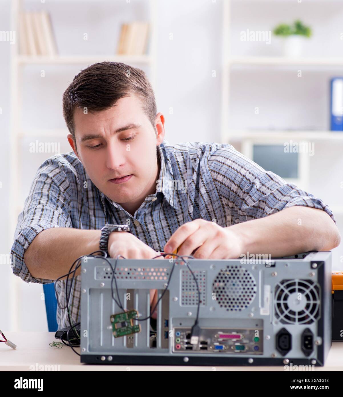The young technician repairing computer in workshop Stock Photo - Alamy