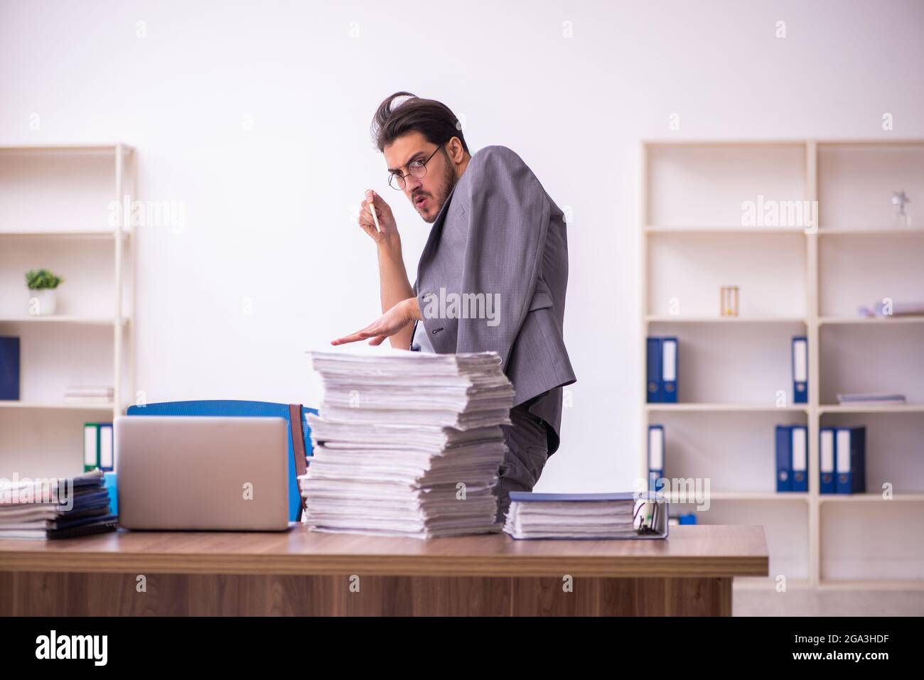 Funny young employee magician and too much work in the office Stock ...