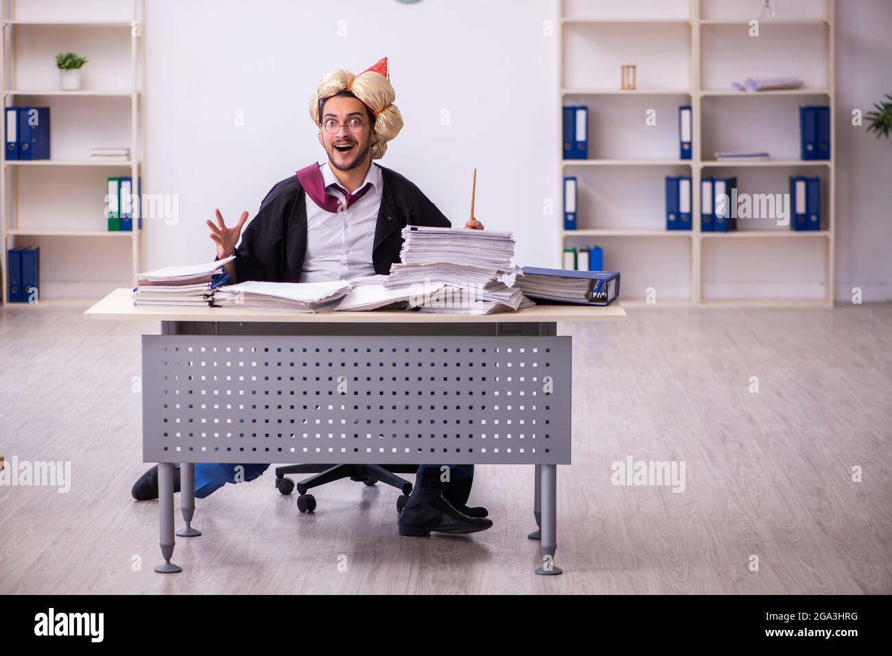 Funny young employee magician and too much work in the office Stock ...