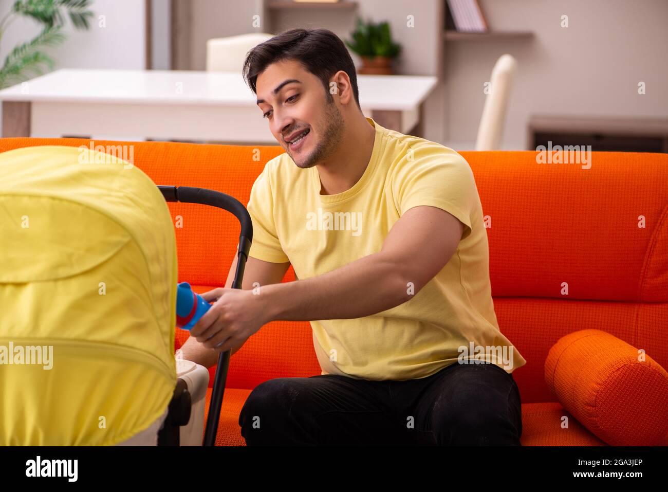 Young man husband looking after new born at home Stock Photo - Alamy