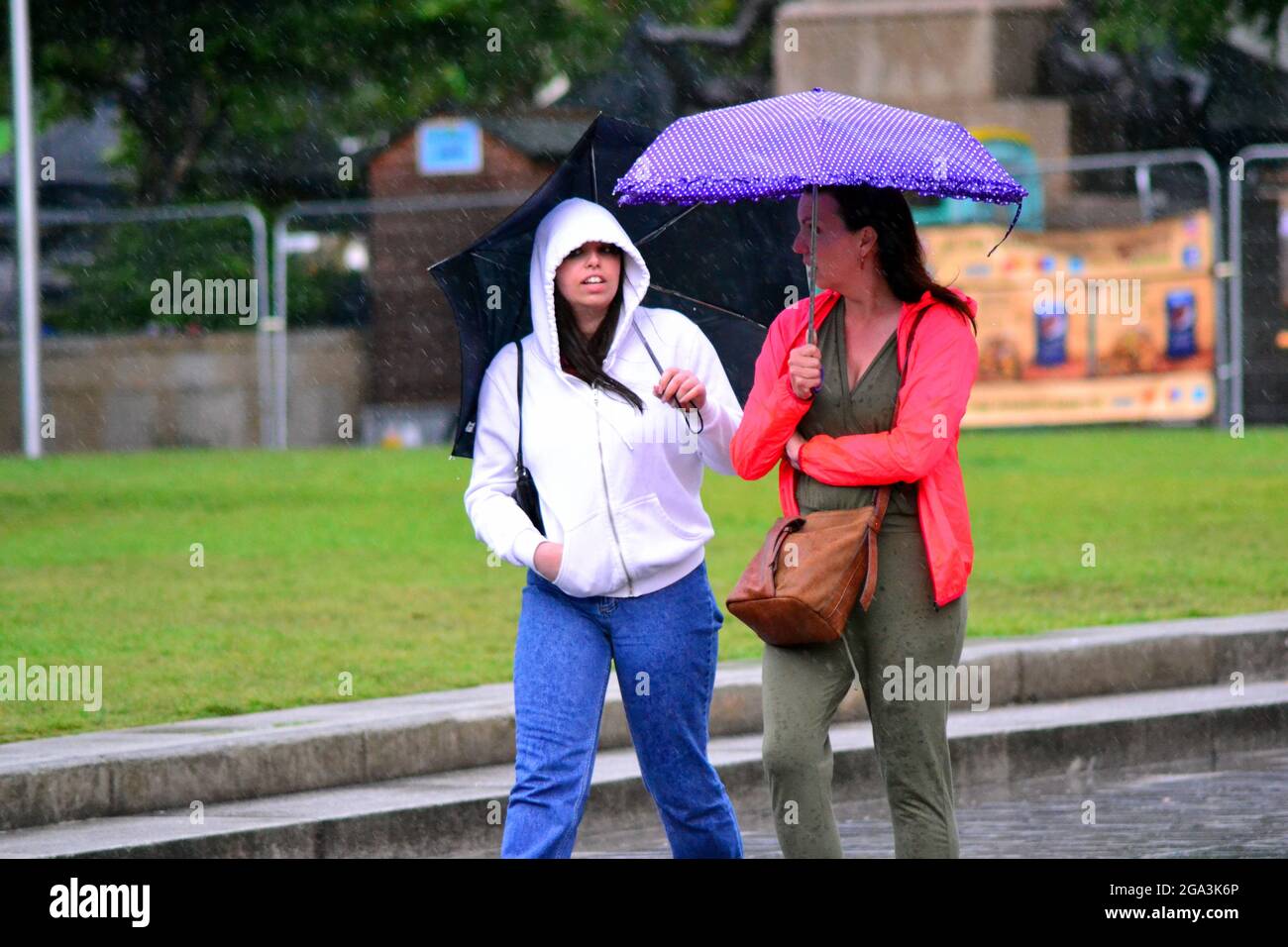 Thunderstorm and heavy rain in city centre, Manchester, UK. People try ...