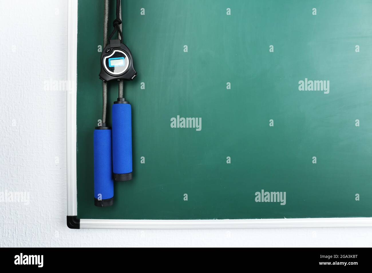 Timer and skipping rope on blackboard background Stock Photo - Alamy