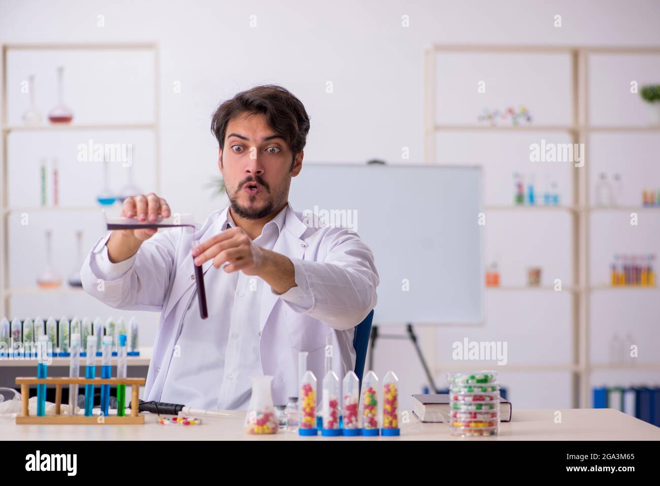 Young chemist in drugs synthesis concept Stock Photo - Alamy