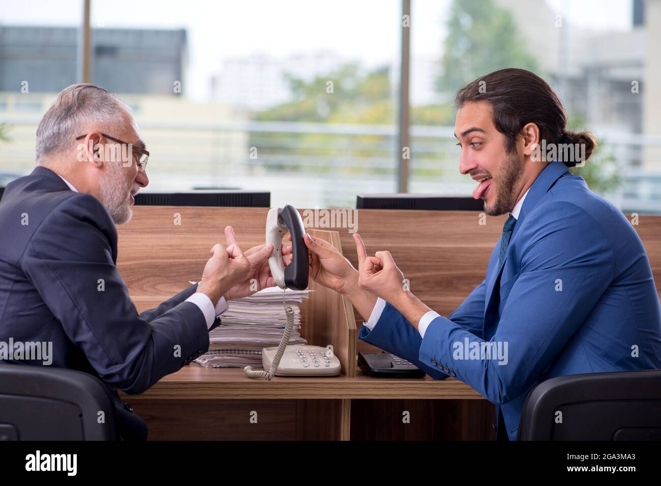 Two businessmen employees sitting in the office Stock Photo - Alamy