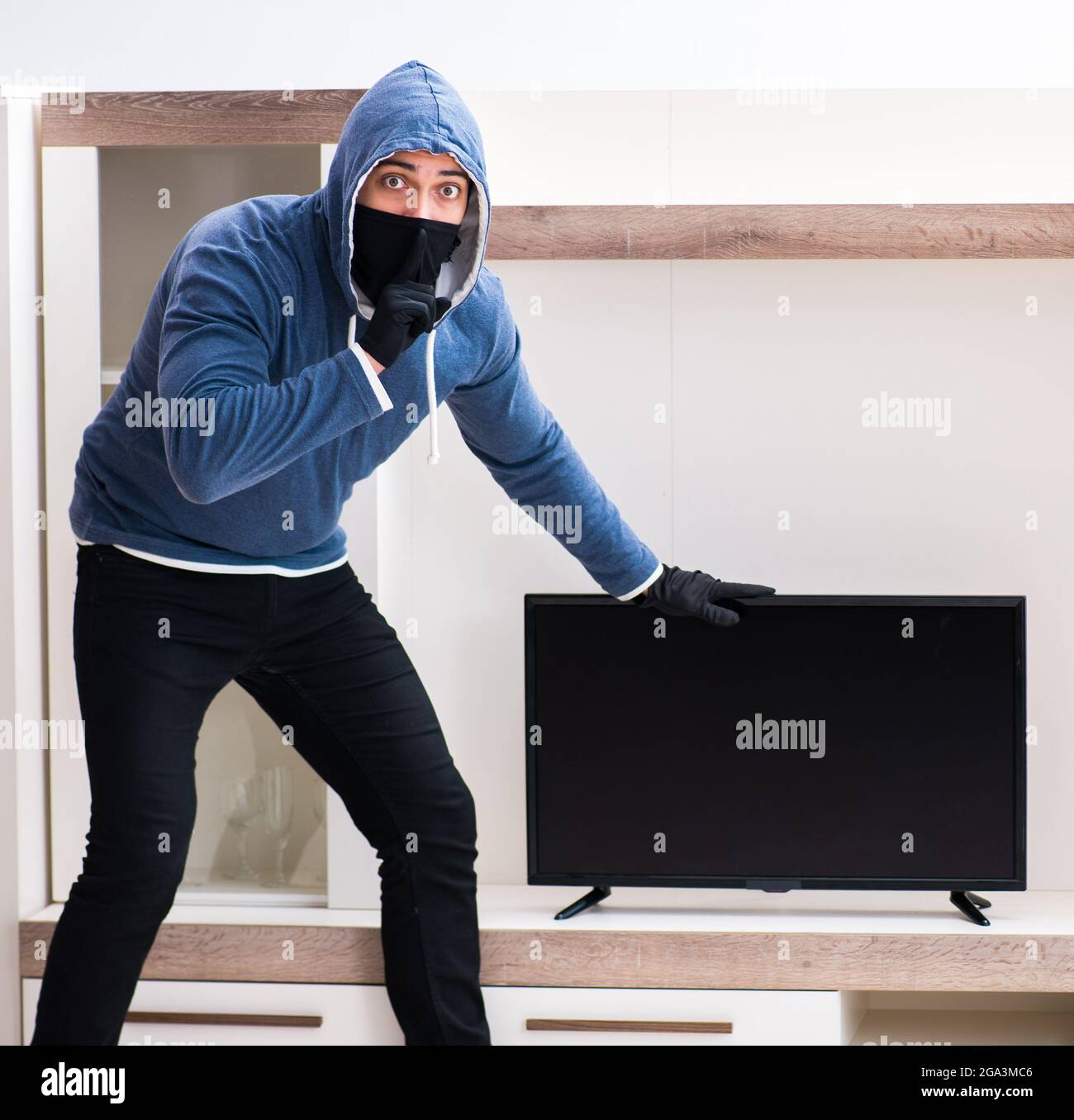 The man burglar stealing tv set from house Stock Photo - Alamy