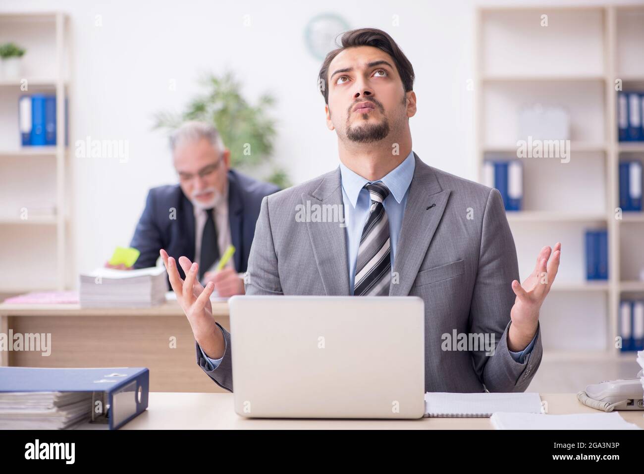 Two male employees working at workplace Stock Photo - Alamy