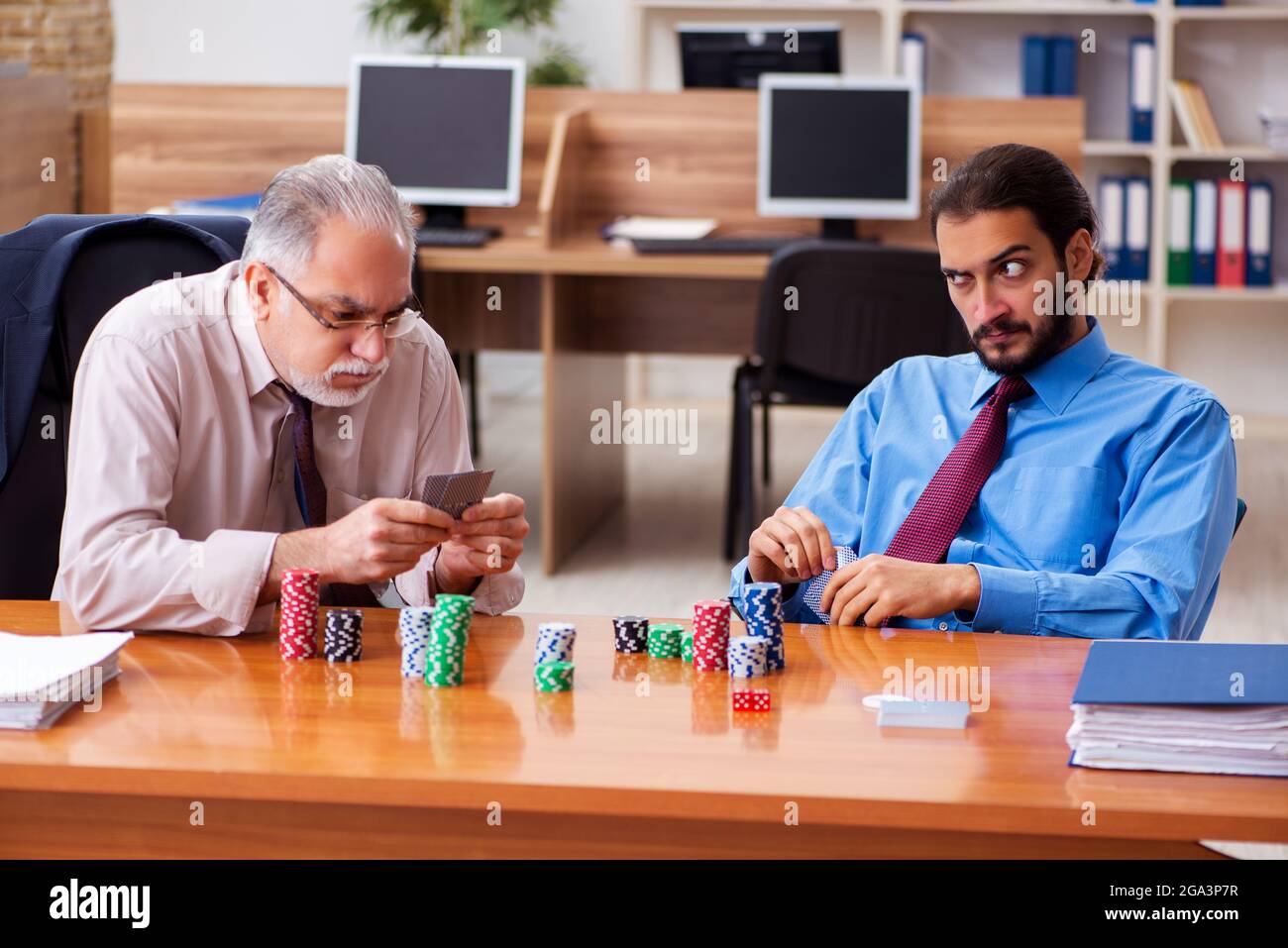 Two employees playing cards at workplace Stock Photo - Alamy