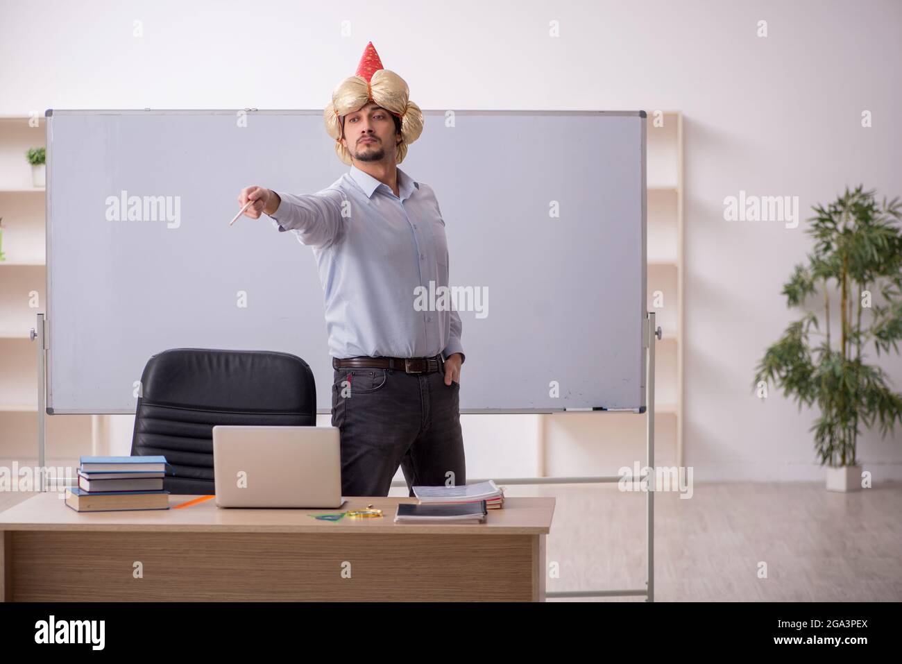 Funny young teacher magician in the classroom Stock Photo - Alamy