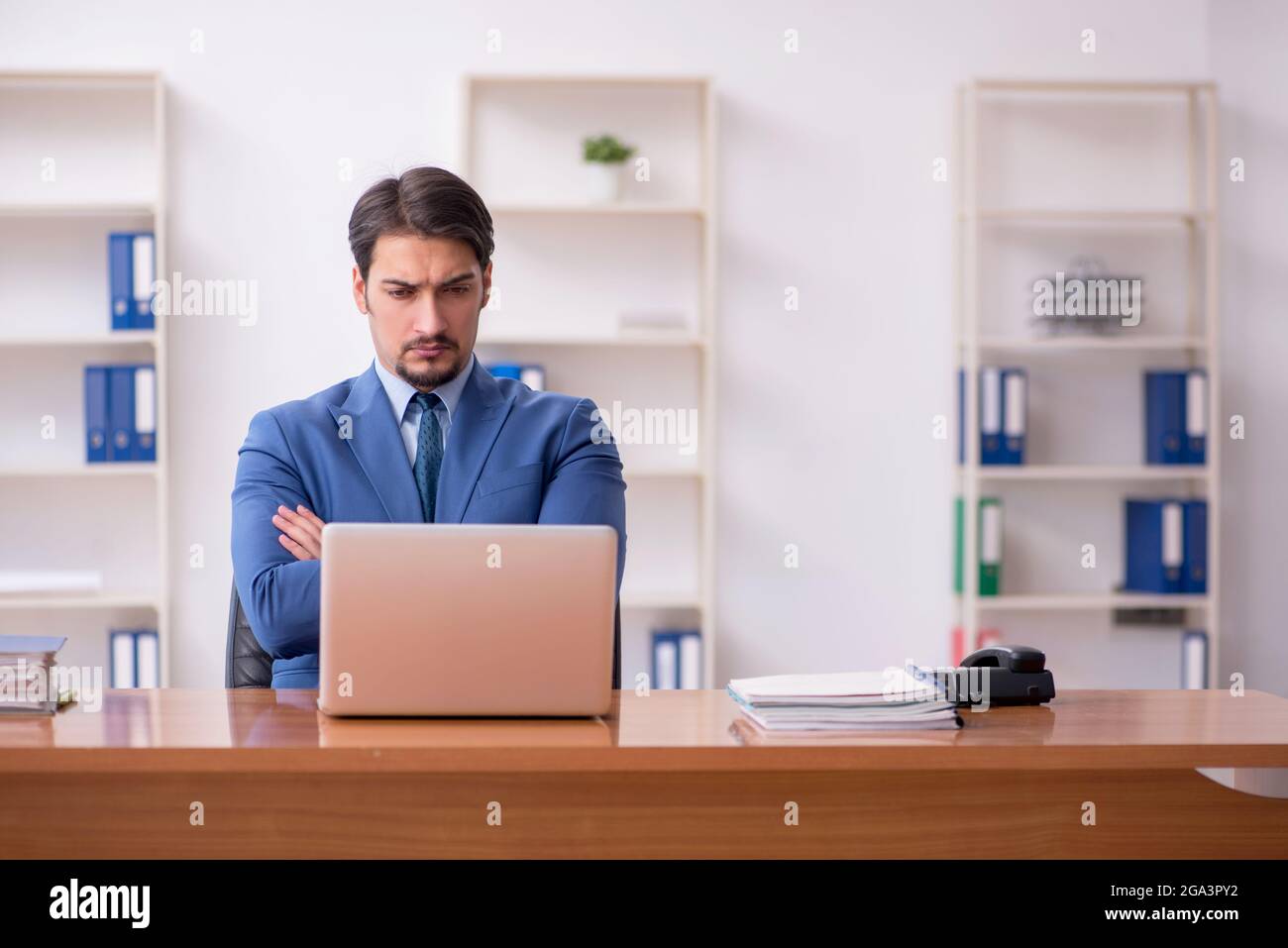 Young male employee working in the office Stock Photo - Alamy