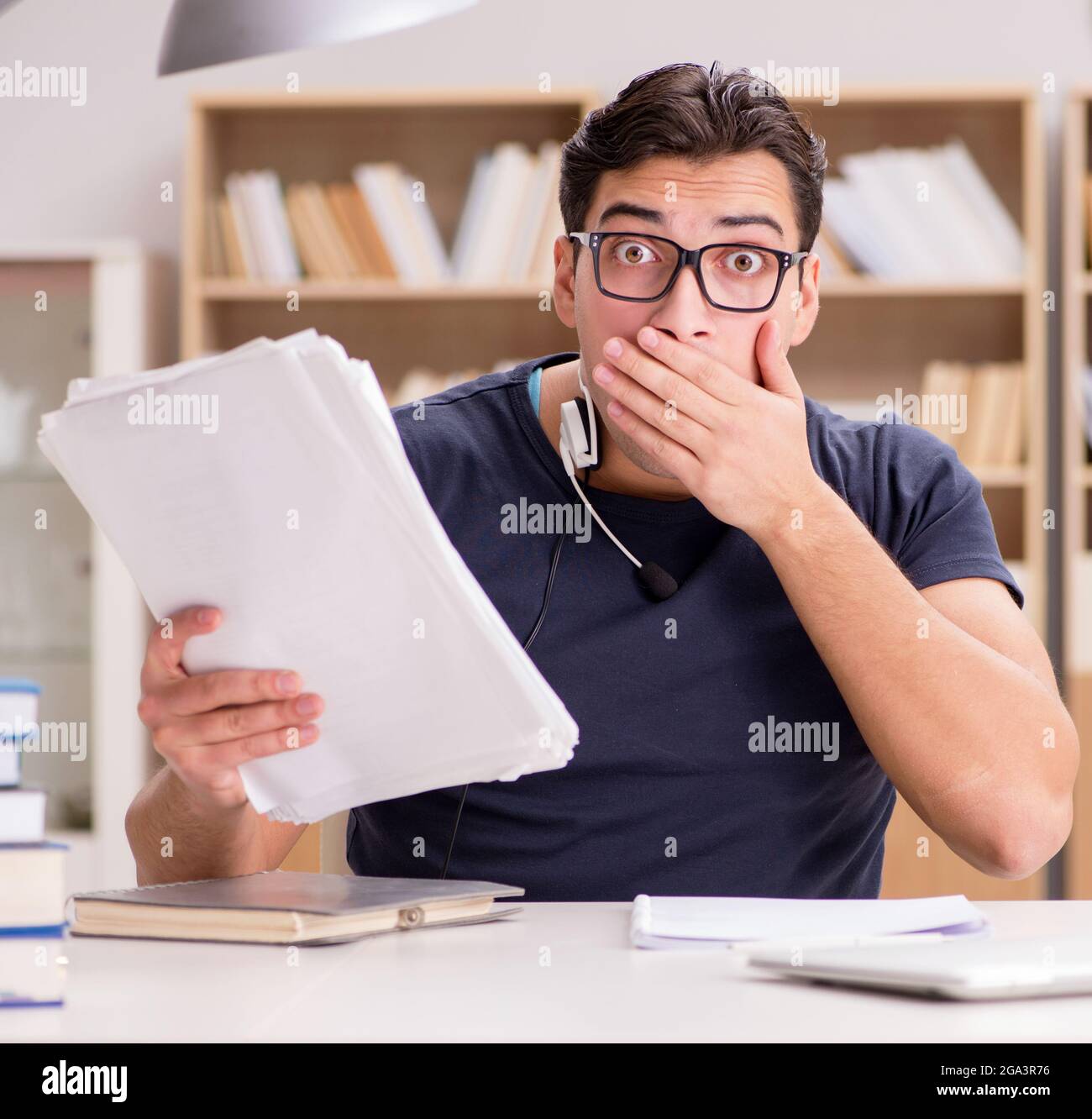 The scared student with paperwork in library Stock Photo - Alamy