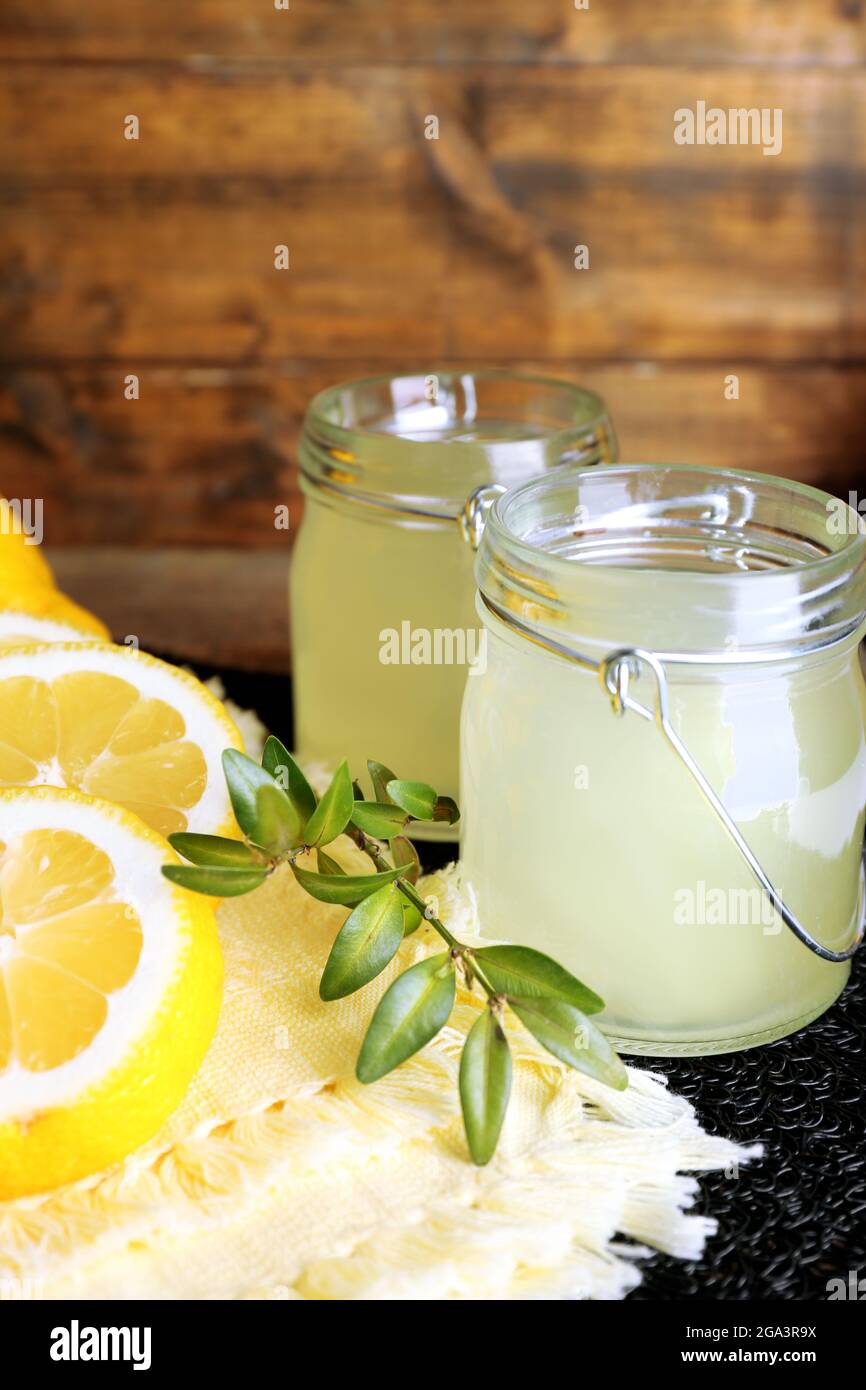 Still life with lemon juice and sliced lemons on wooden background ...