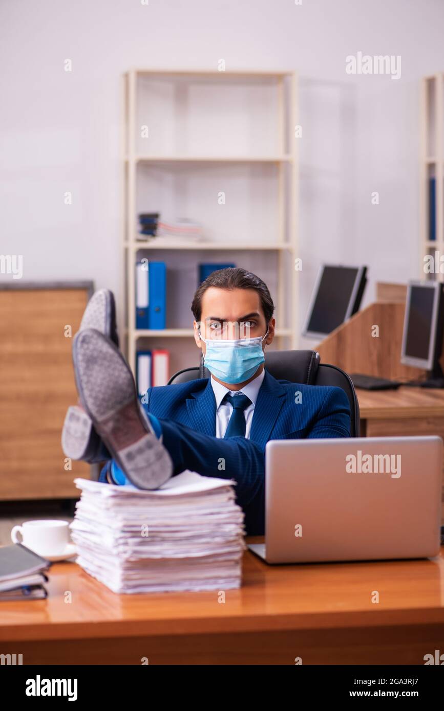 Young employee working in the office wearing mask Stock Photo - Alamy