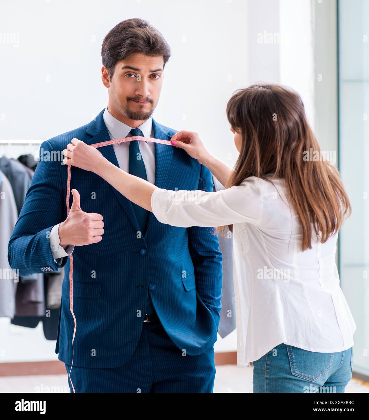 The professional tailor taking measurements for formal suit Stock Photo ...