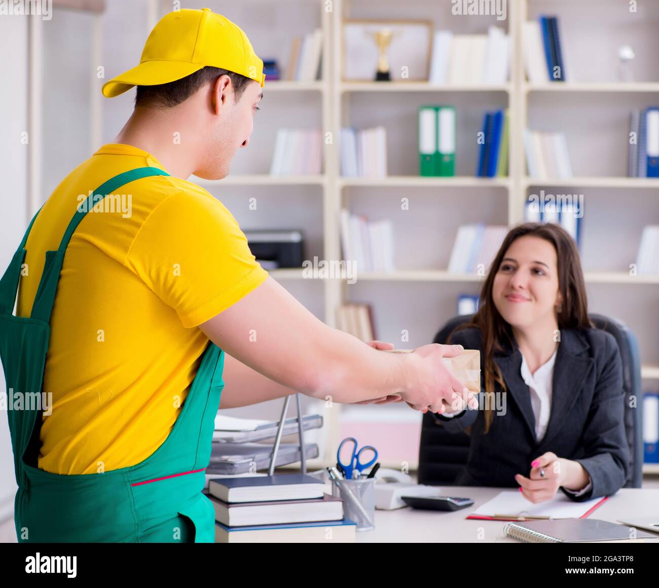 The postman delivering parcel to the office Stock Photo - Alamy
