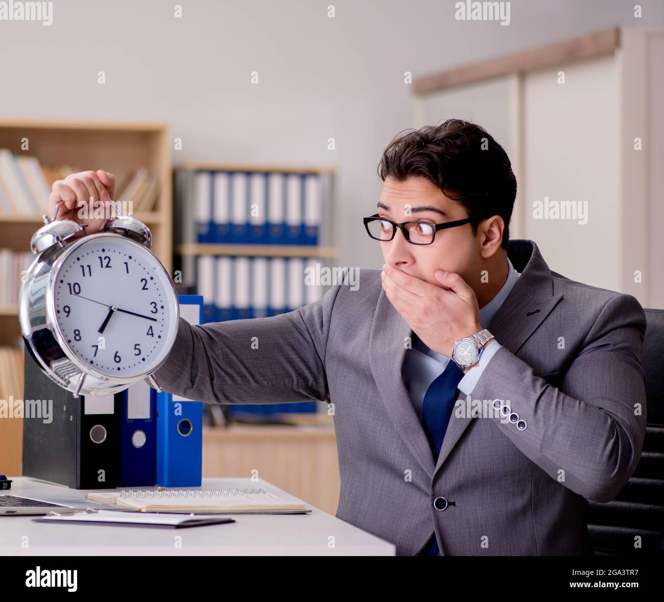 The businessman with clock failing to meet deadlines Stock Photo - Alamy