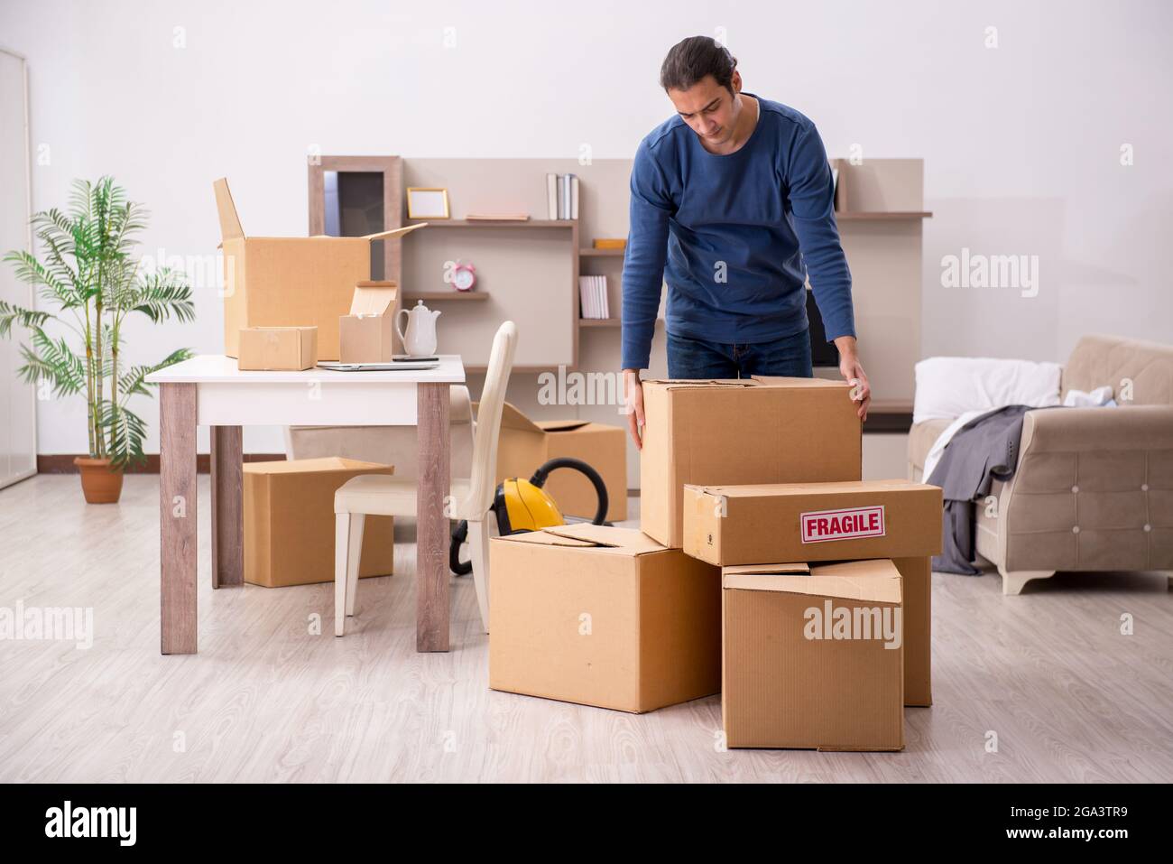 Young handsome man moving to new flat Stock Photo - Alamy