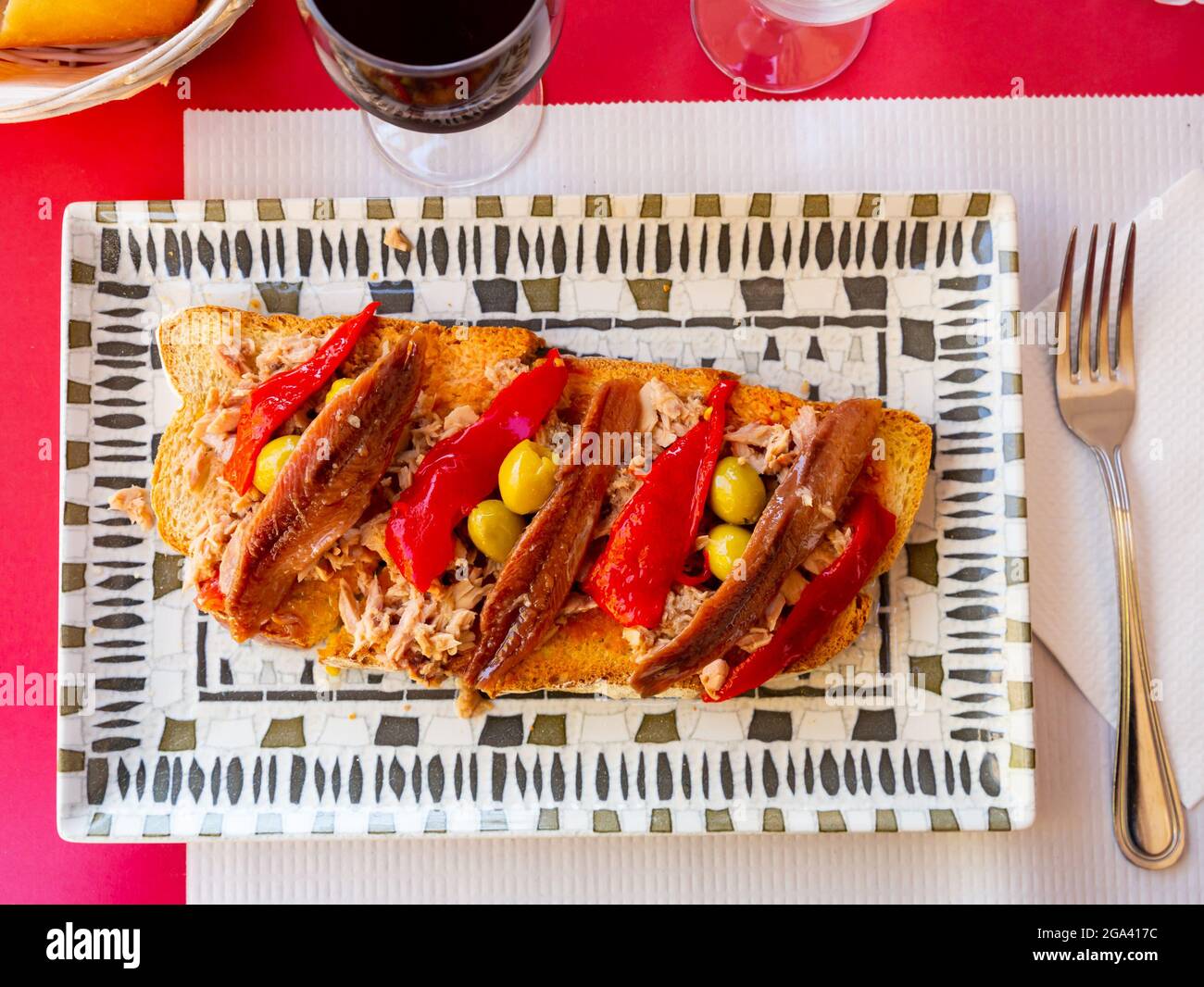 Toasted bread with tuna, anchovies, baked bell pepper and olives Stock ...