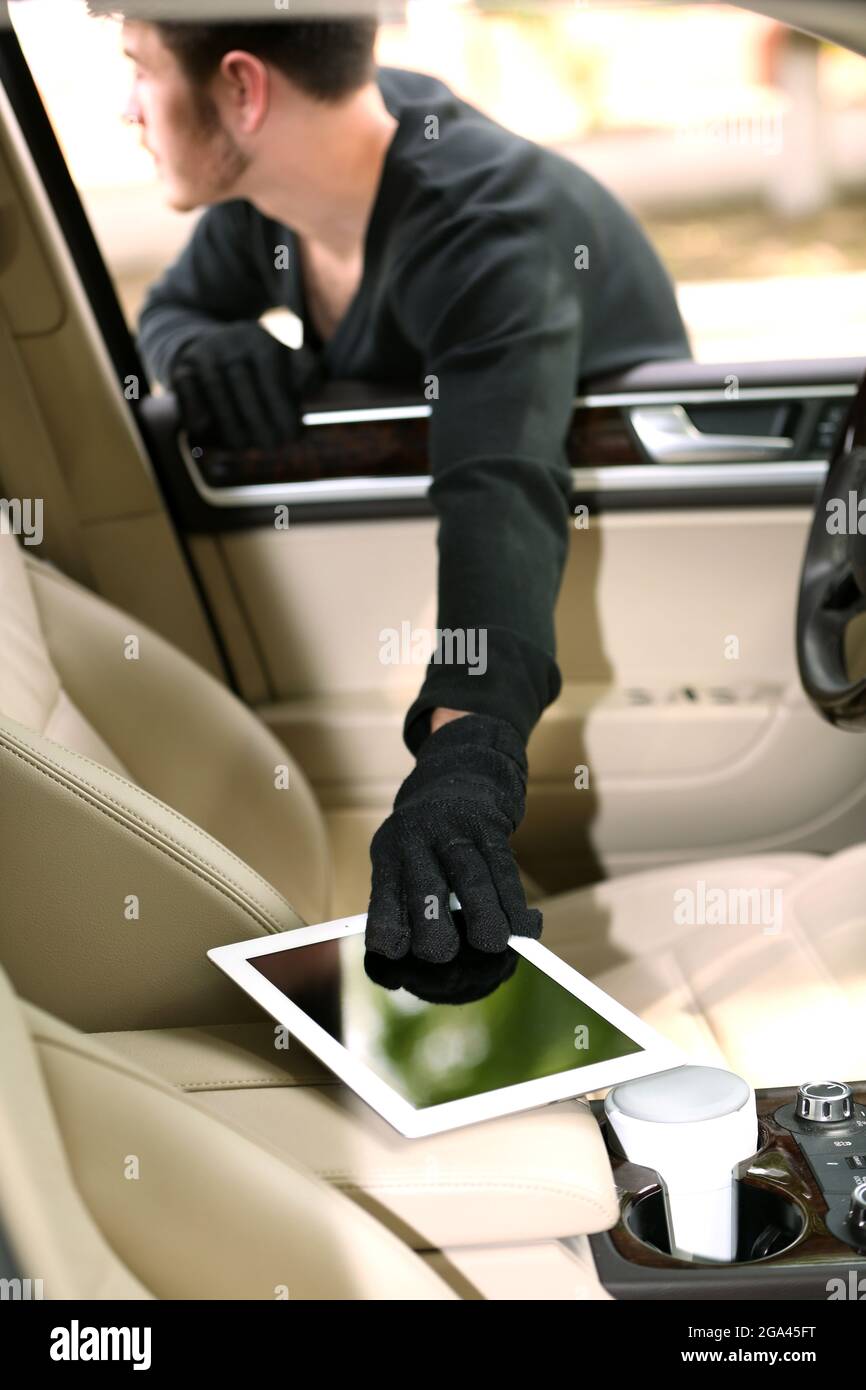 Man burglar steals the tablet of car Stock Photo - Alamy