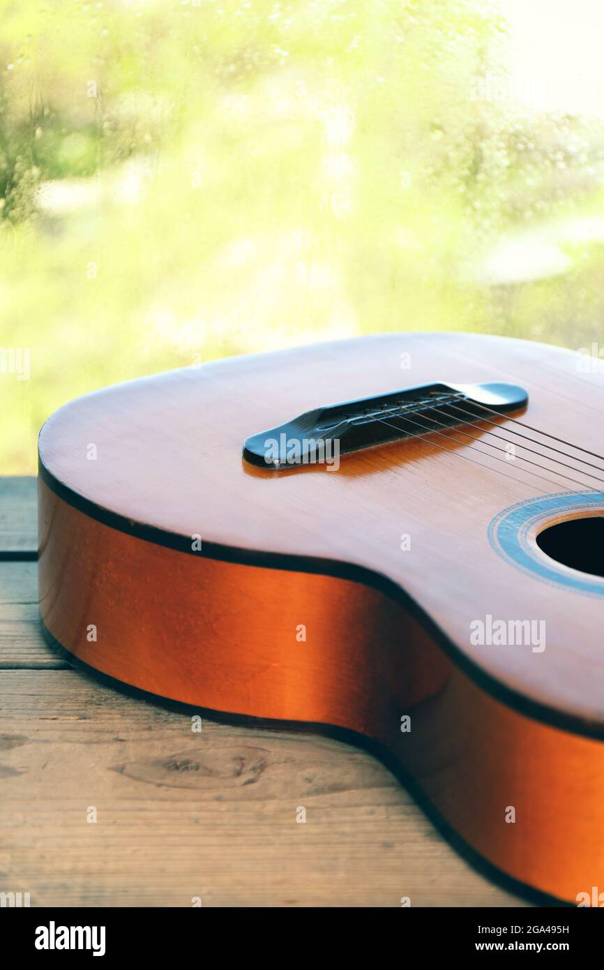 Acoustic guitar next the window with rain drops Stock Photo - Alamy