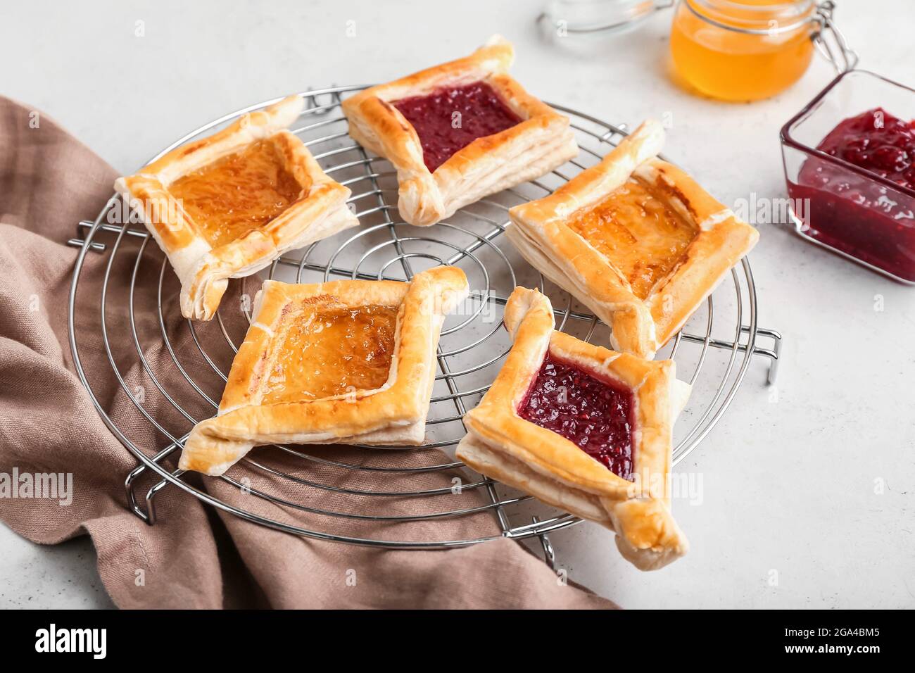 Cooling grid with Danish pastry on light background Stock Photo - Alamy