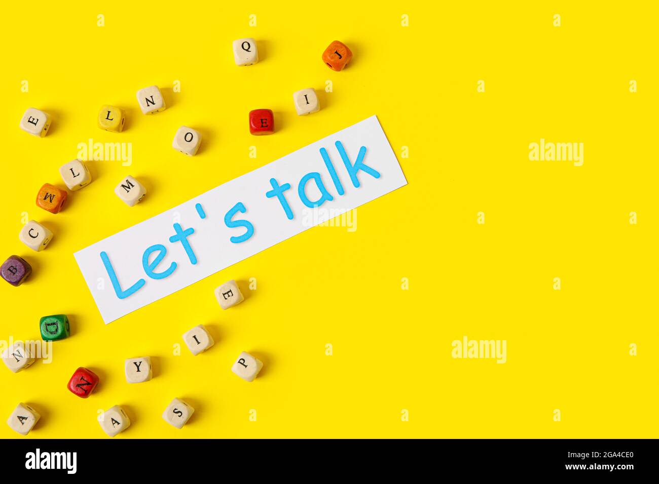 Paper with text LET'S TALK and cubes with letters on color background ...