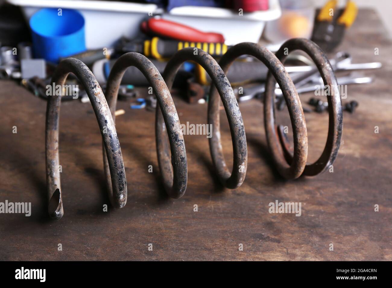 Large metal spring on workplace in garage Stock Photo - Alamy