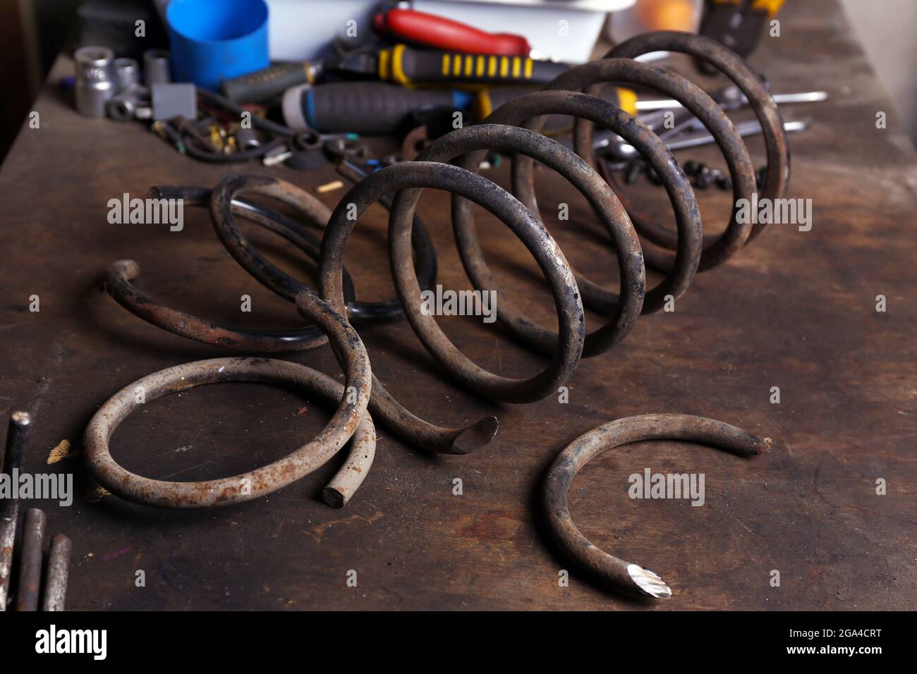 Large metal spring on workplace in garage Stock Photo - Alamy