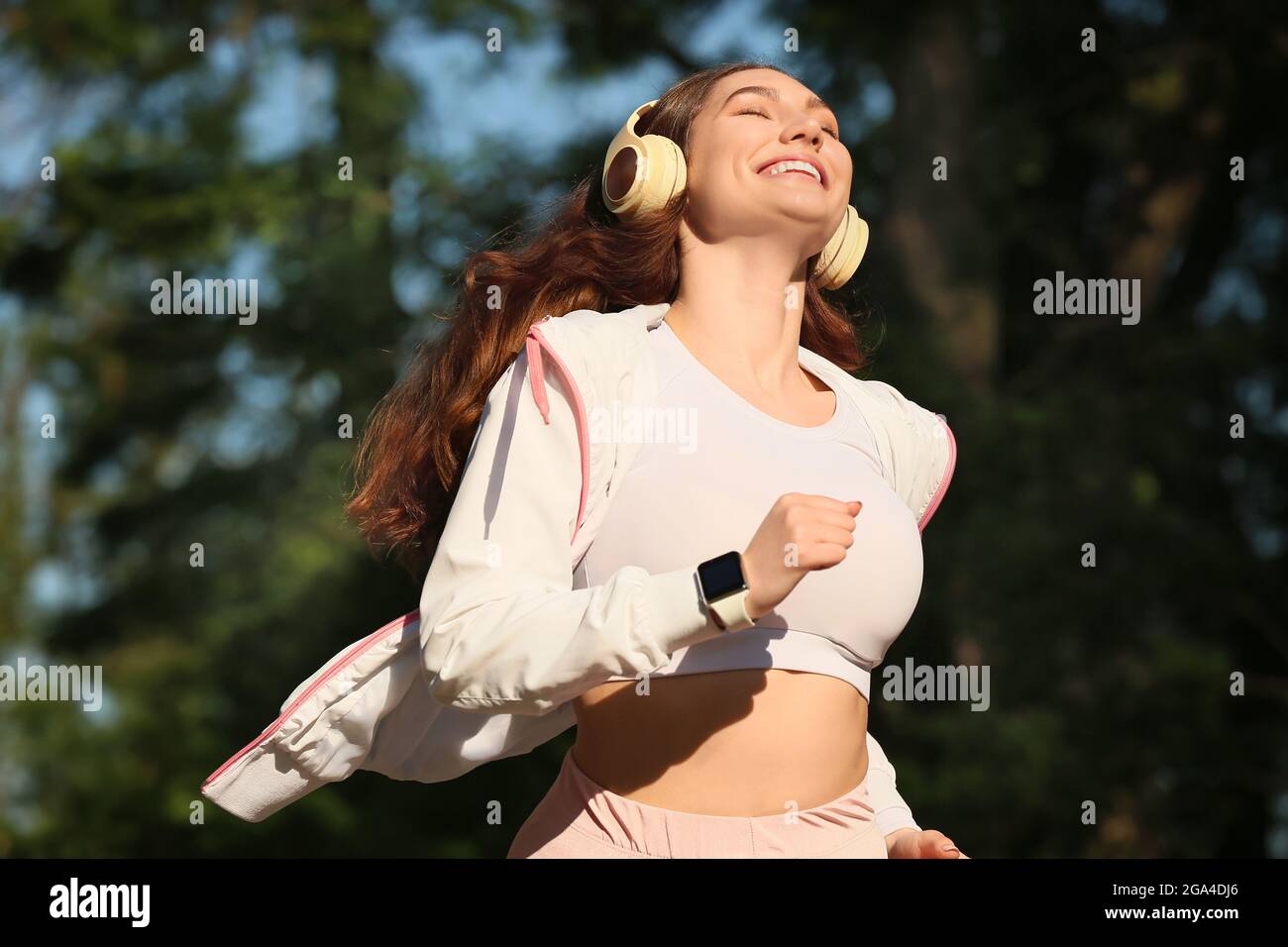 Sporty young woman listening to music while running outdoors Stock ...