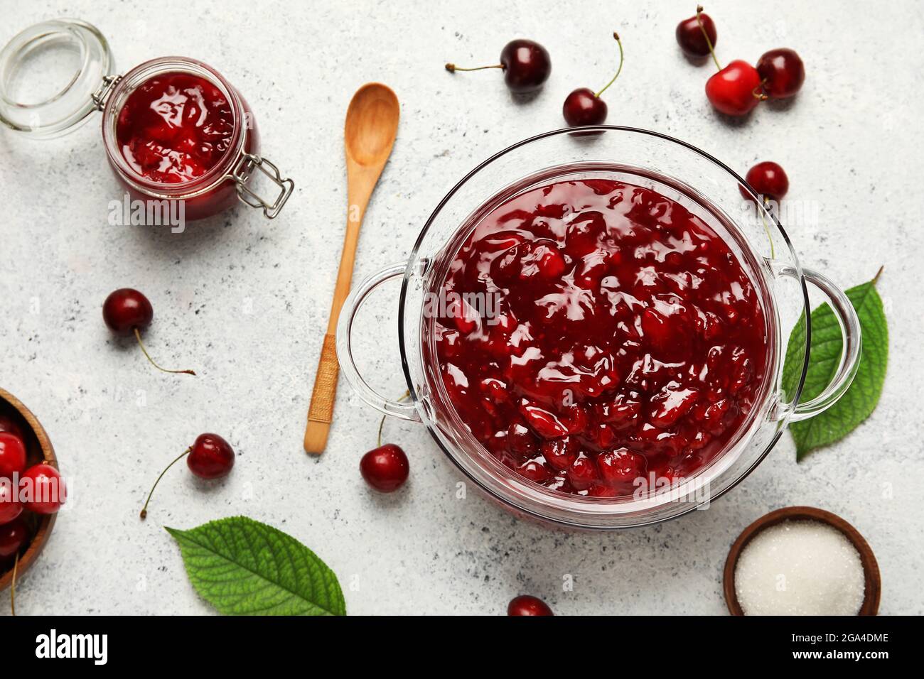 Composition with sweet cherry jam on light background Stock Photo - Alamy