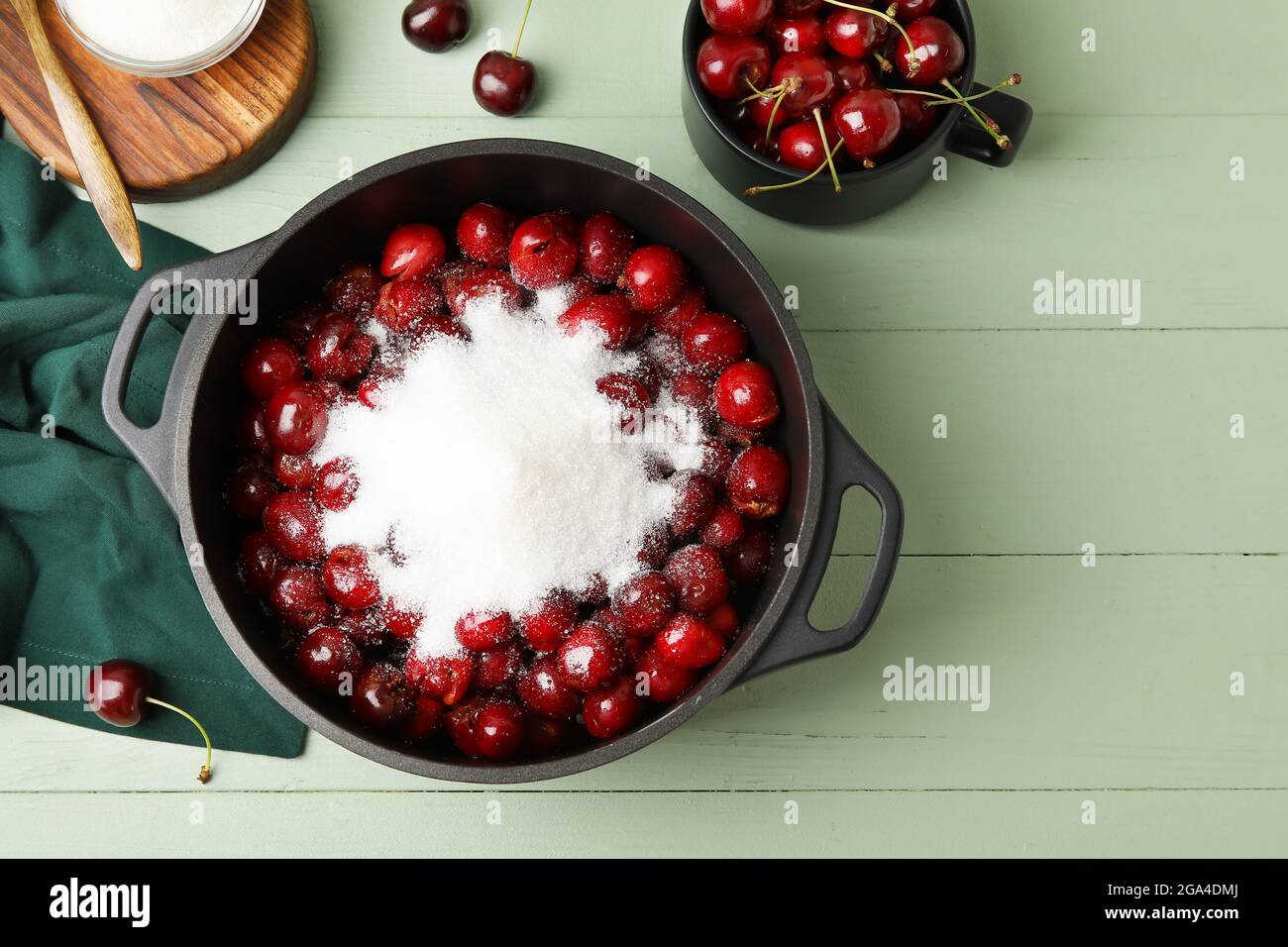 Preparing of sweet cherry jam on color wooden background Stock Photo ...