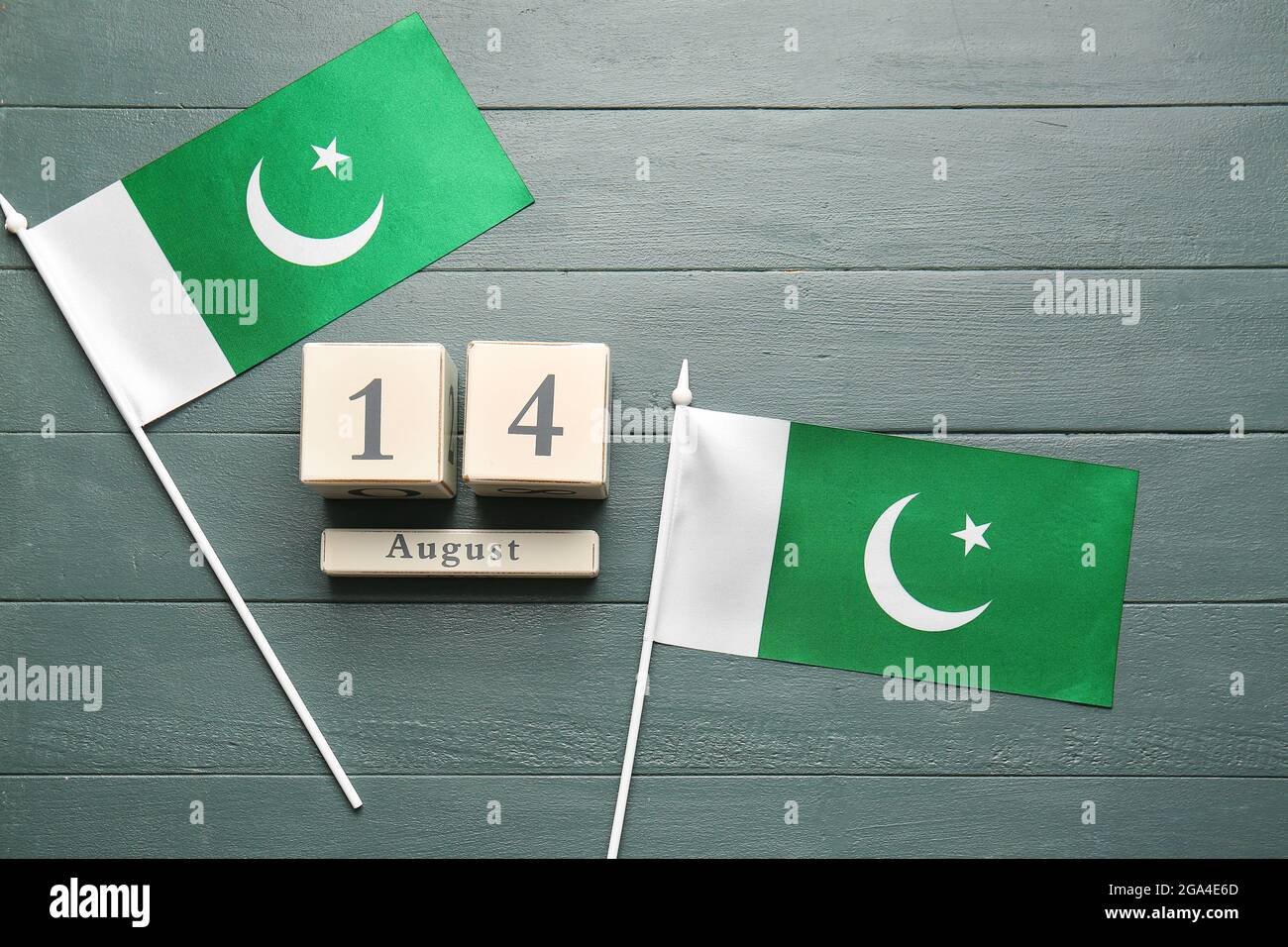 Flags of Pakistan and calendar with date of Independence Day on wooden ...