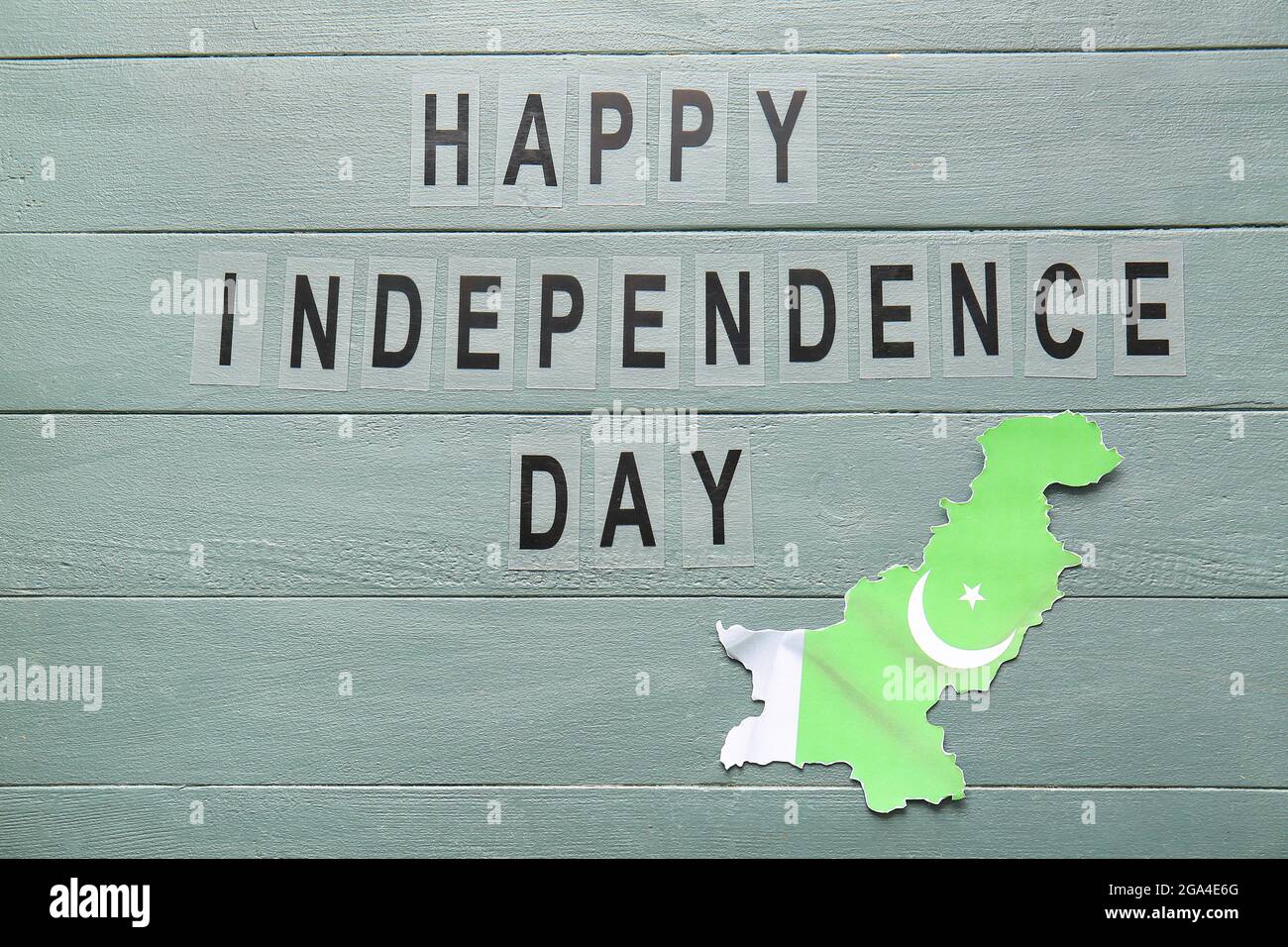 Flag map of Pakistan and text HAPPY INDEPENDENCE DAY on wooden ...
