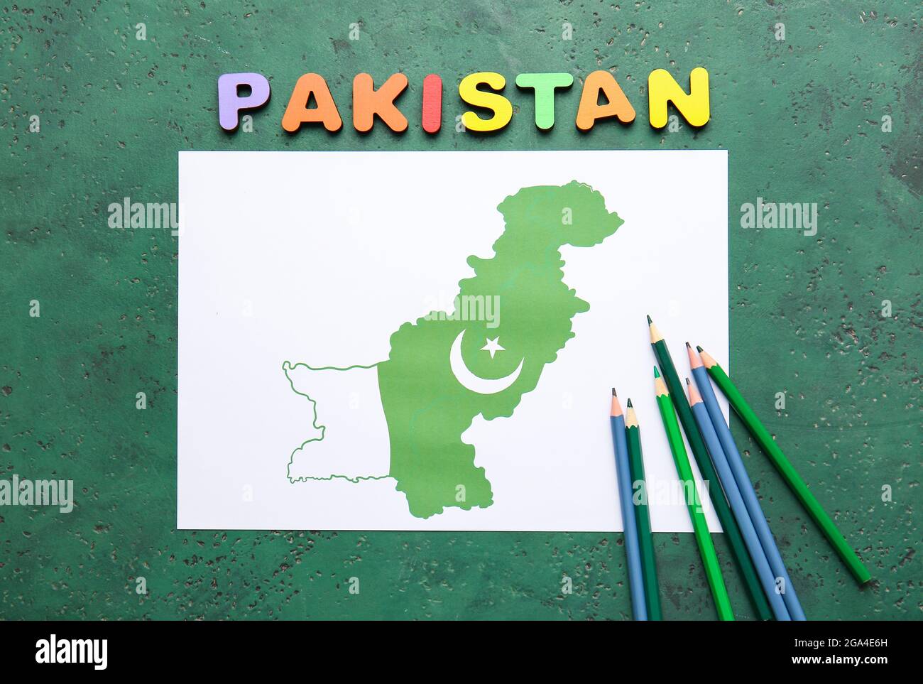 Paper sheet with flag map of Pakistan and pencils on color background ...