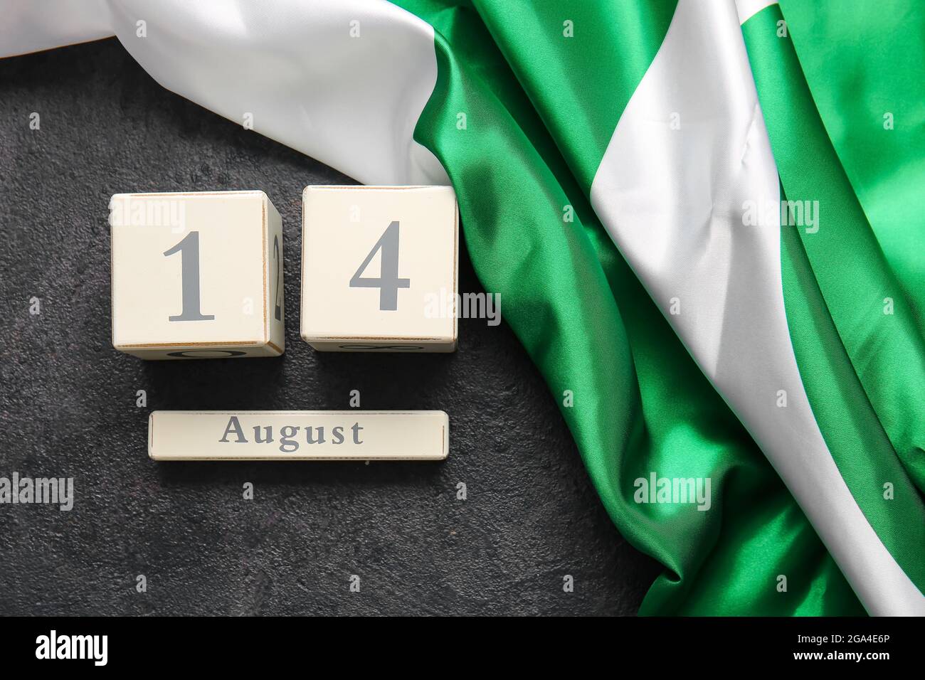 Flag of Pakistan and calendar with date of Independence Day on dark ...