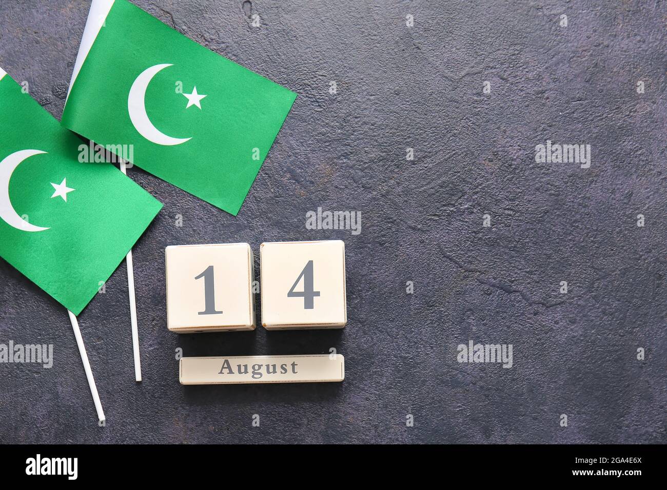 Flags of Pakistan and calendar with date of Independence Day on dark ...