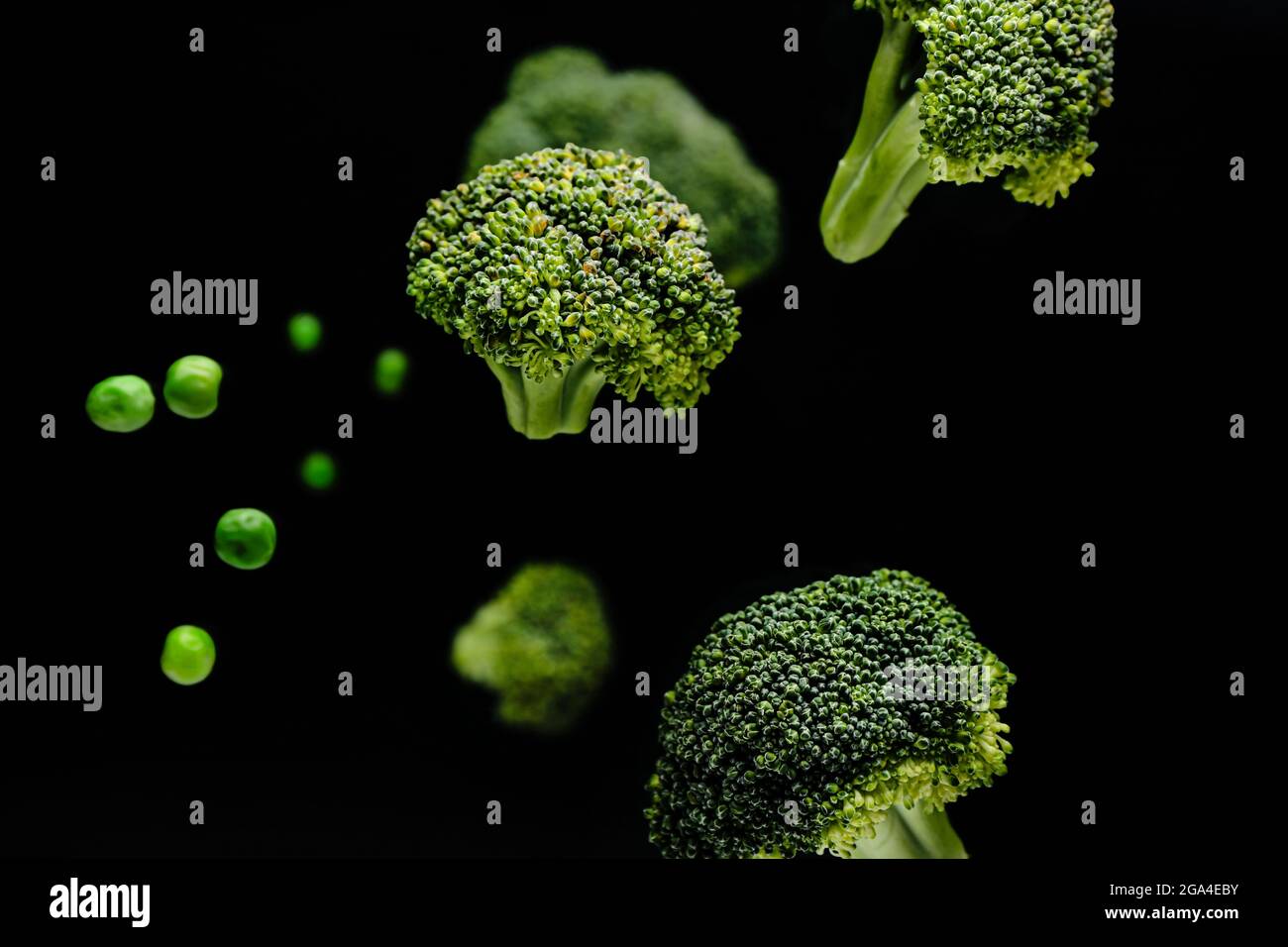 Flying green peas and broccoli on dark background Stock Photo - Alamy