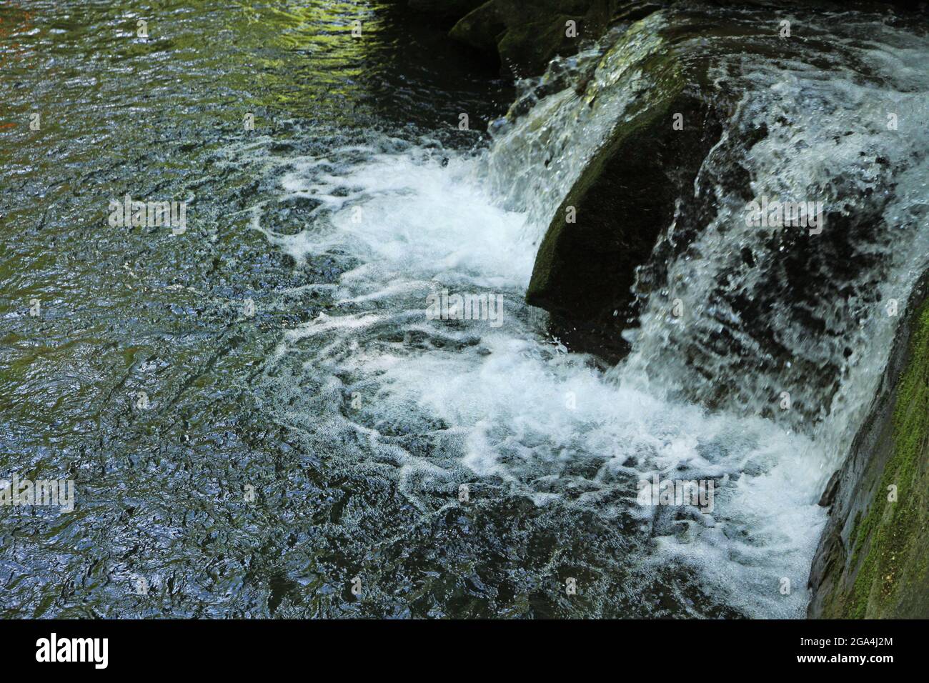 Water flowing on rocks in park Stock Photo - Alamy