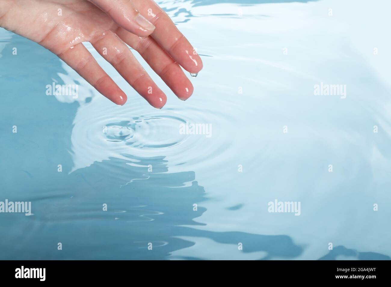 Finger touches water close up Stock Photo - Alamy
