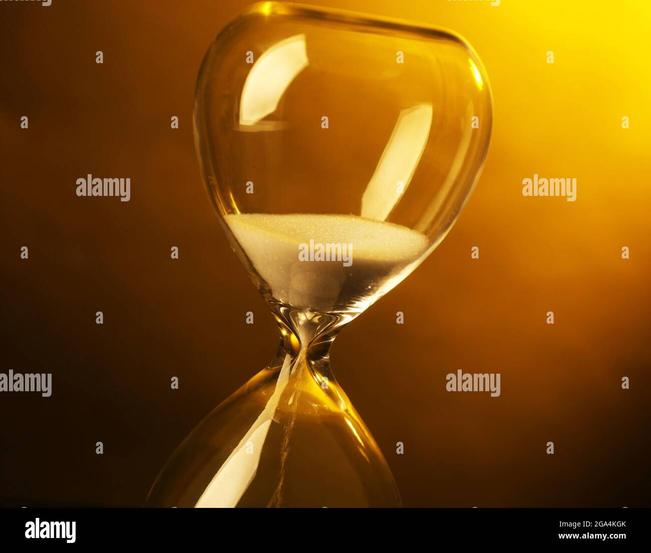 Hourglass on colour background Stock Photo - Alamy