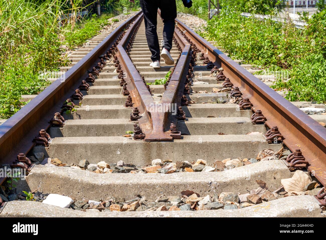 A man walking on old rusty railway tracks outdoors Stock Photo - Alamy