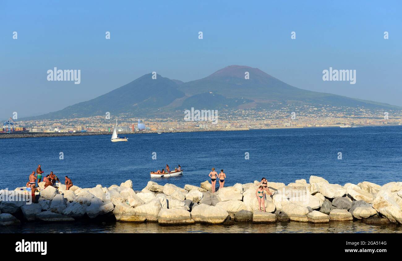 A group of Italian young women sunbathing on the wave breakers by the ...