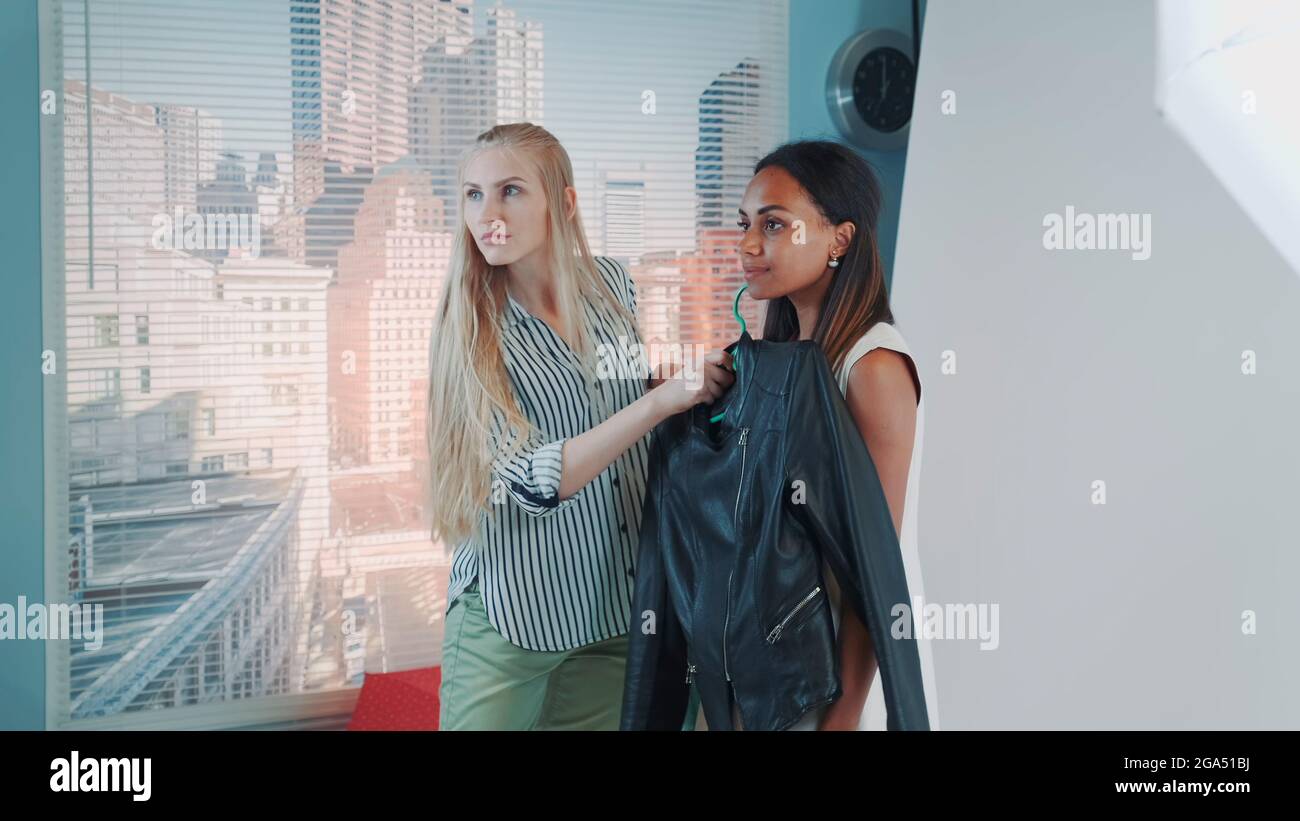 Female fashion stylist proposing black model different clothes for ...