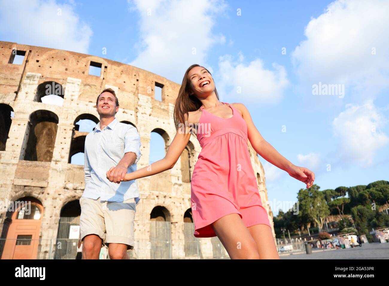 Travel Couple in Rome by Colosseum running fun Stock Photo - Alamy
