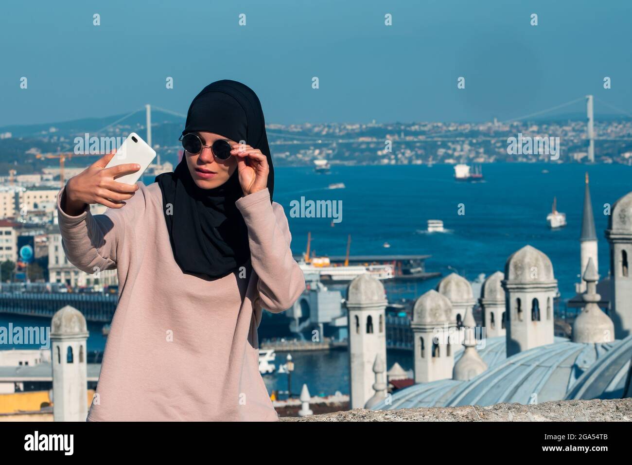 A stylish Muslim woman takes a selfie near the Suleymaniye Mosque Stock ...